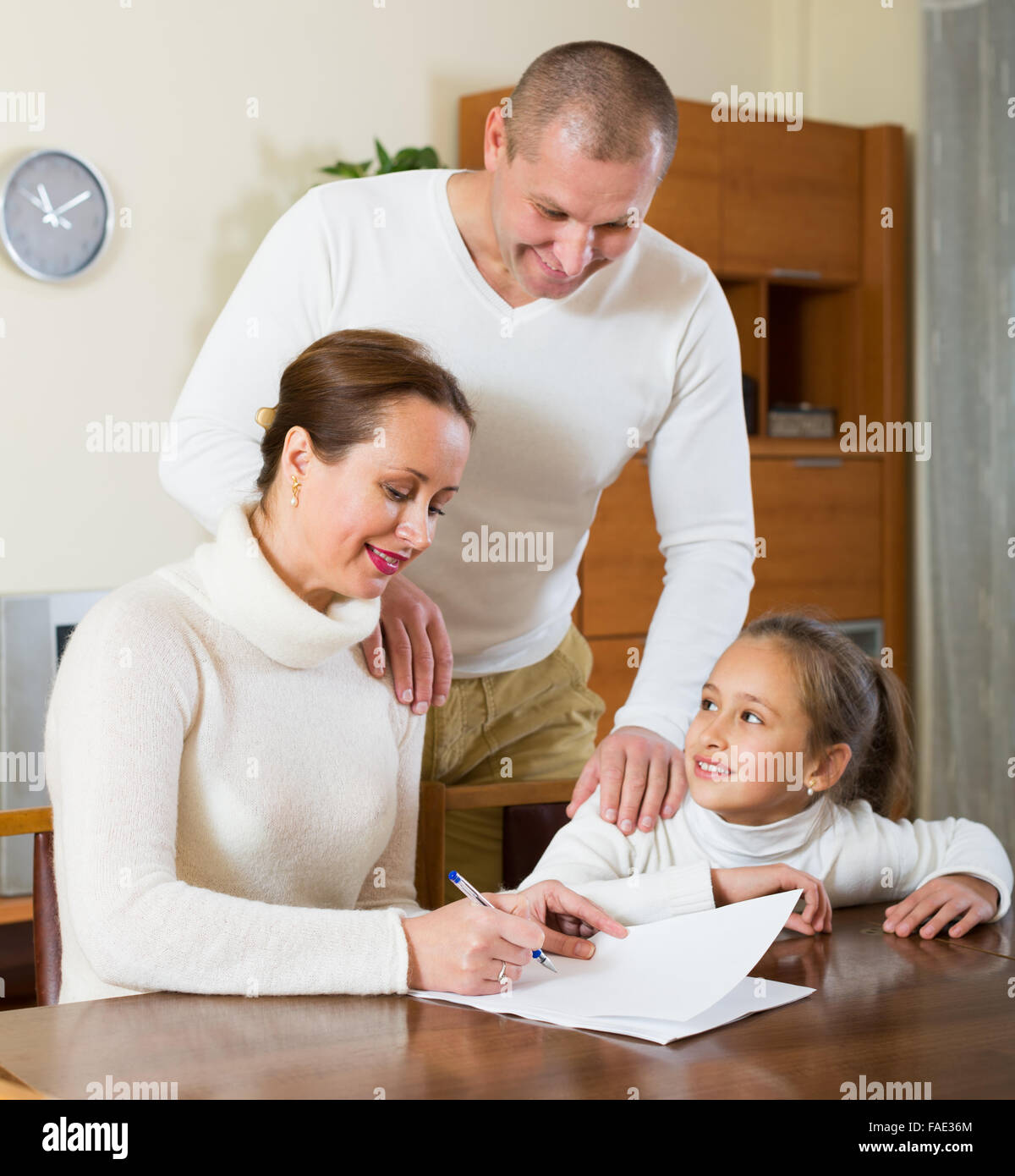 Happy parents and child with documents at the table Stock Photo - Alamy