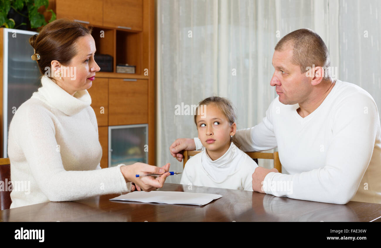Sad family with documents at table in home Stock Photo - Alamy