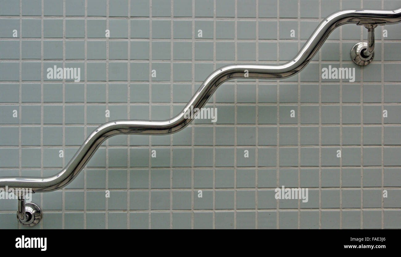 Wobbly chrome handrail on tiled subway wall Stock Photo - Alamy
