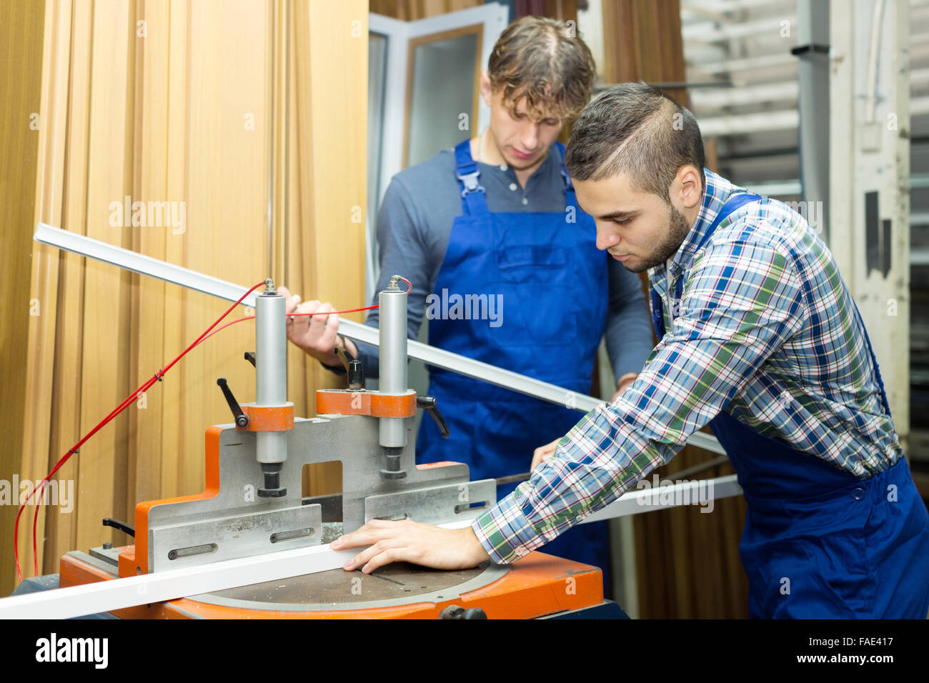 A couple of workers toil around the milling machine Stock Photo - Alamy
