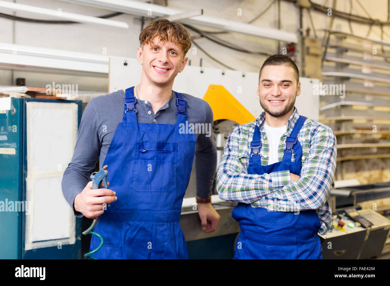 A couple of smiling adult men around the milling machine Stock Photo ...