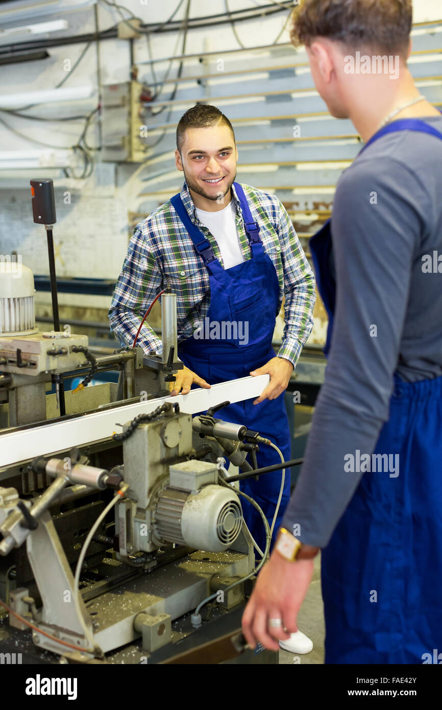 Two males do his job on a machine in factory Stock Photo - Alamy