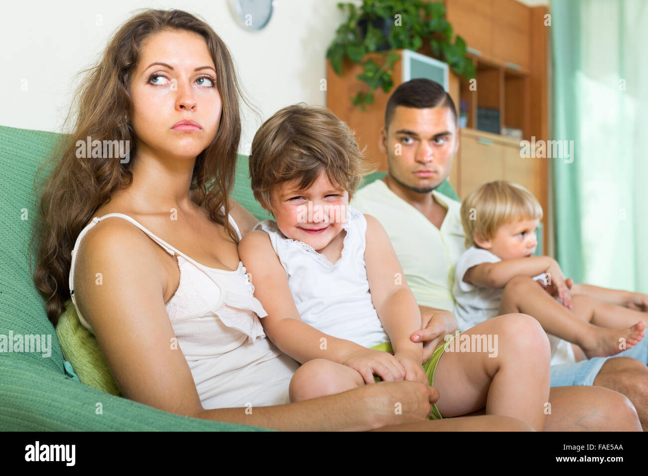 Sad young family with two little daughters after quarrel at home Stock ...