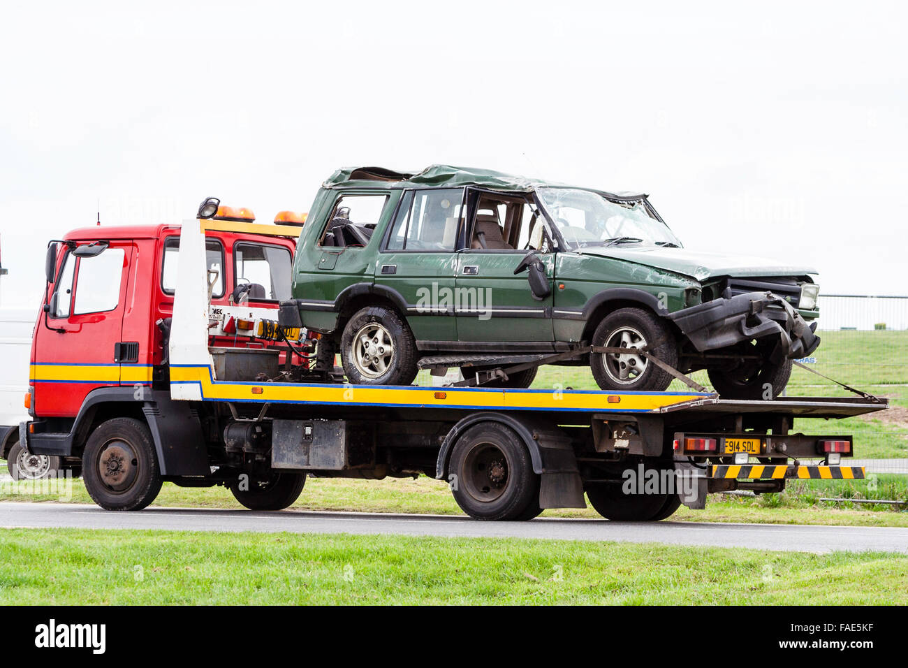 Badly damaged write-off green car, Range-Rover secured on recovery ...