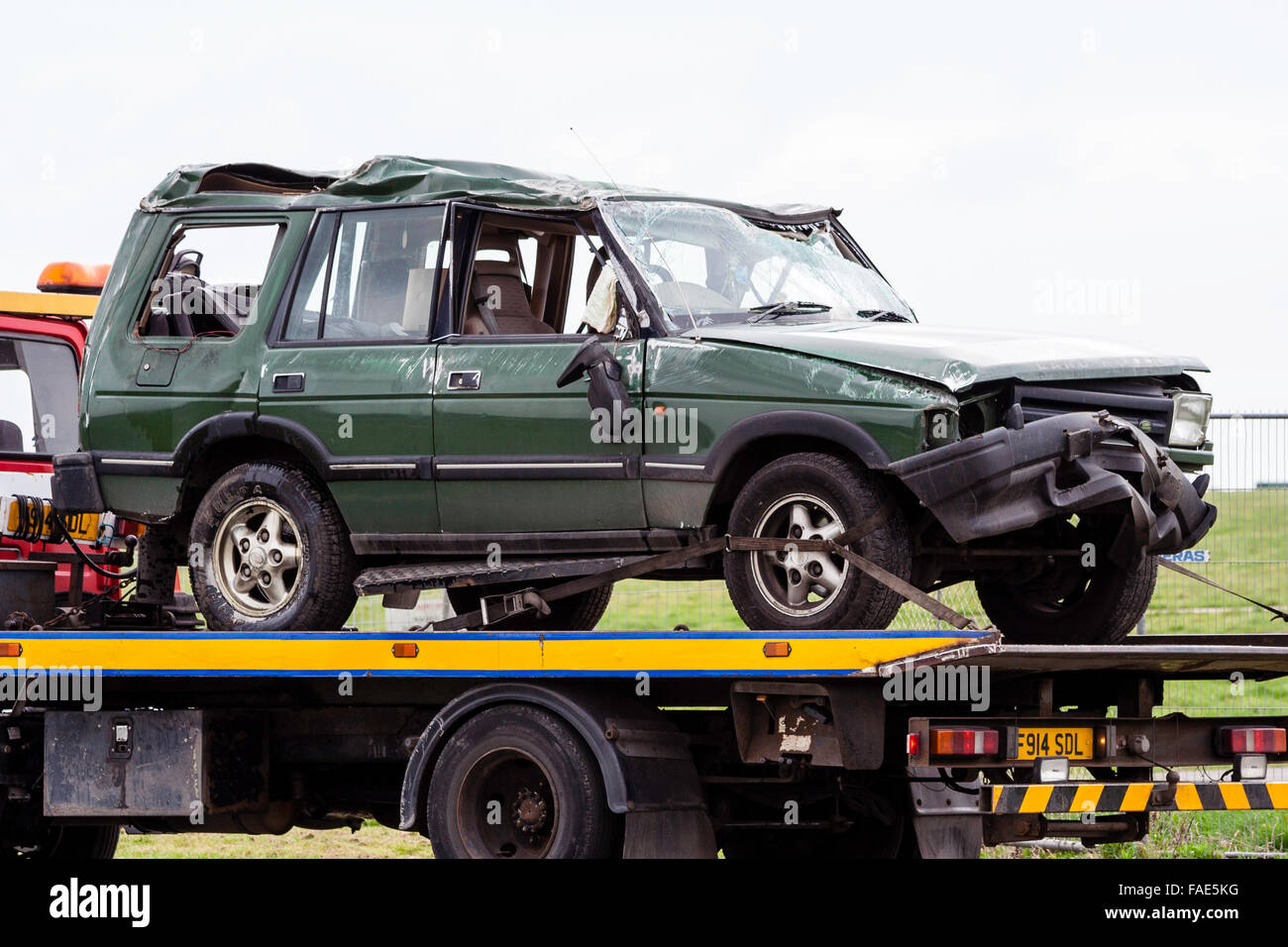 Badly damaged write-off green car, Range-Rover secured on recovery ...