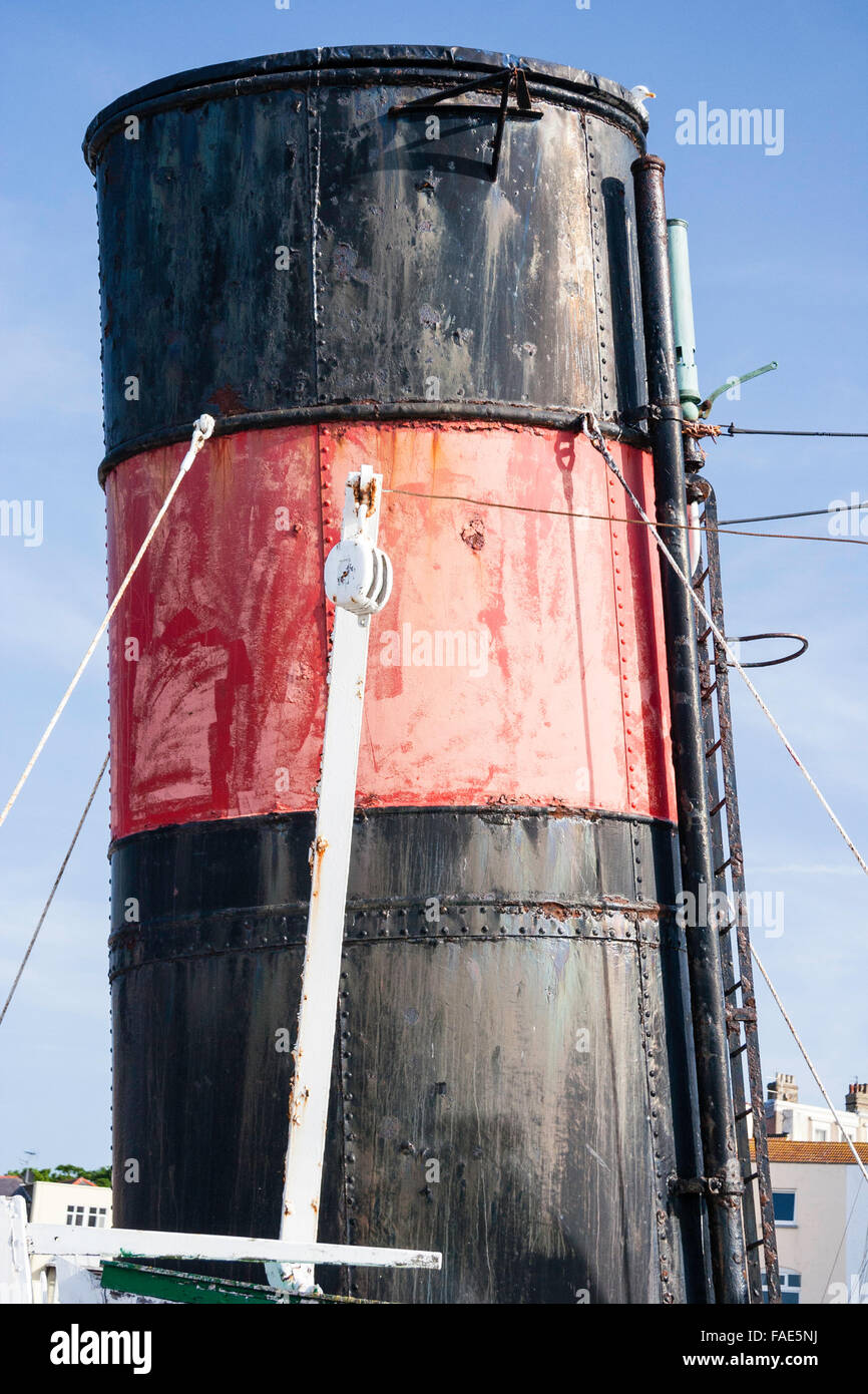 Close up of black and red weathered ship's funnel against blue sky ...