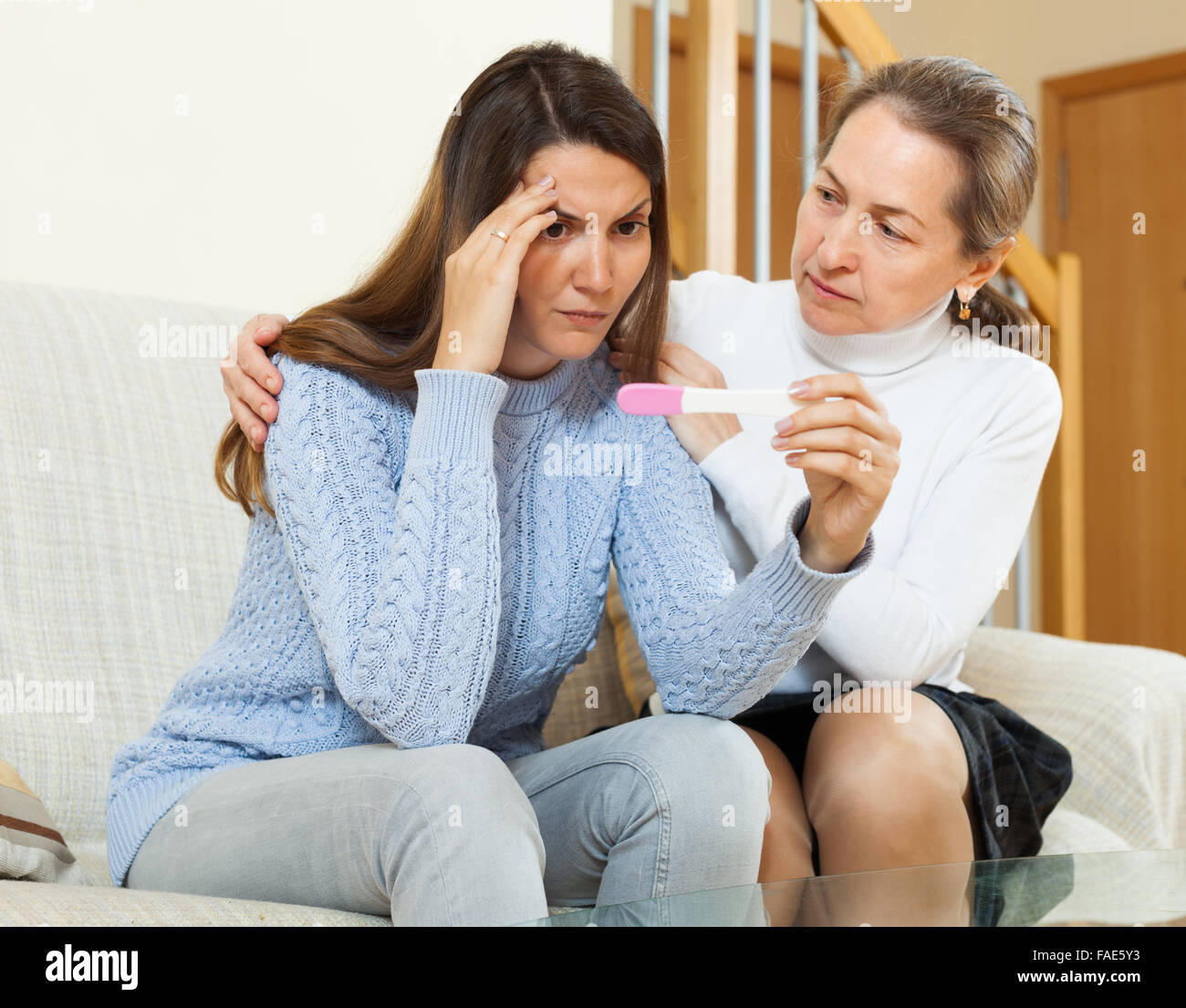 Woman consoling the sad teen daughter with pregnancy test at home Stock ...