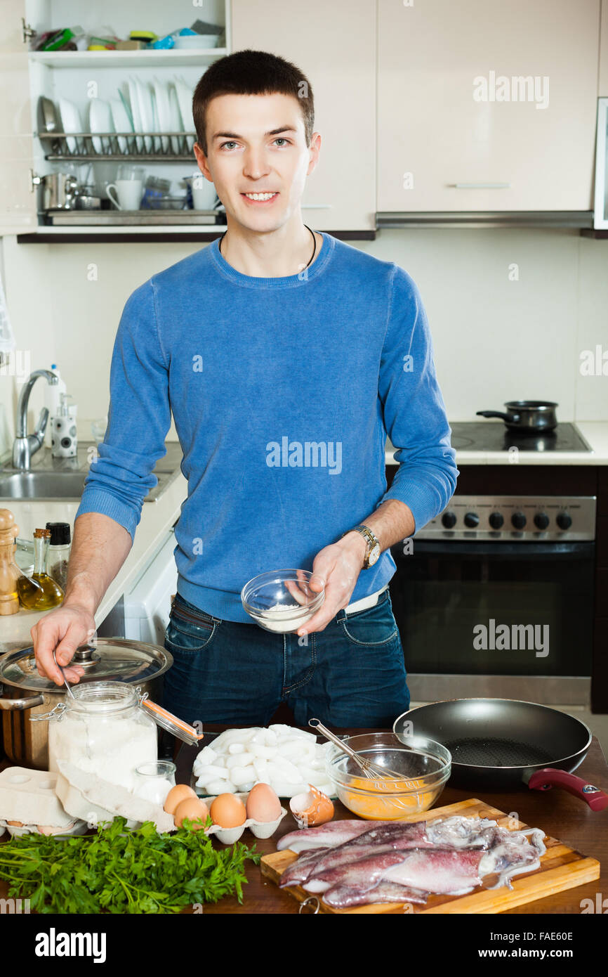 Smiling boy preparing batter for cooking calamari rings Stock Photo - Alamy