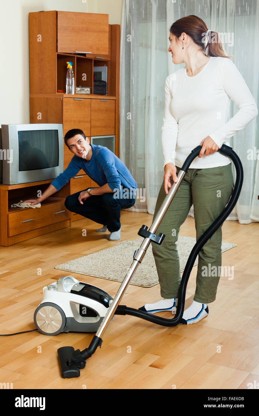 Happy adult couple doing housework together in home Stock Photo - Alamy