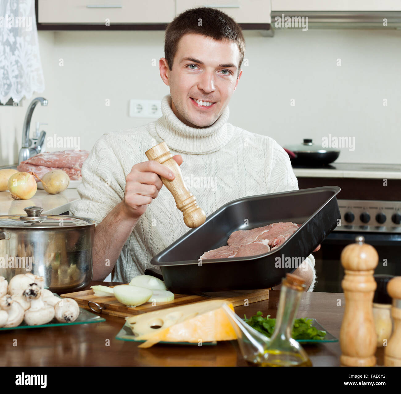 Guy cooking raw meat in home kitchen Stock Photo - Alamy