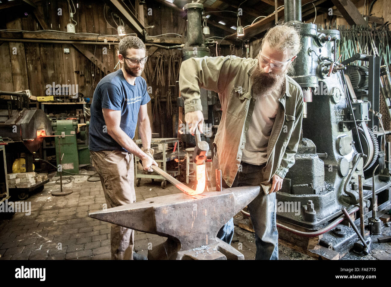 Blacksmith in his Forge with an apprentice Stock Photo - Alamy