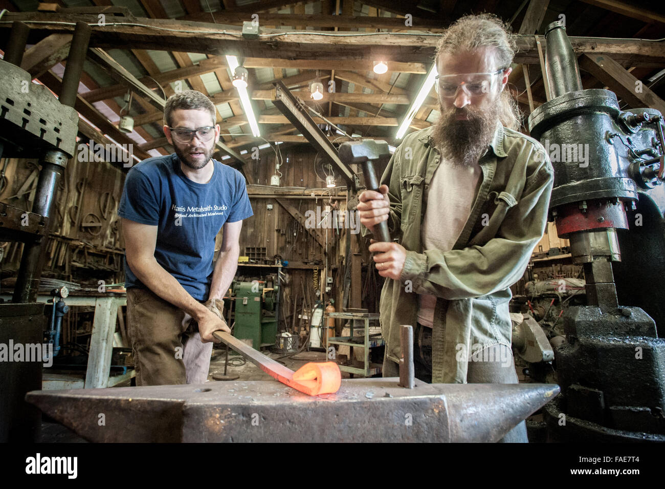 Blacksmith in his Forge with an apprentice Stock Photo - Alamy