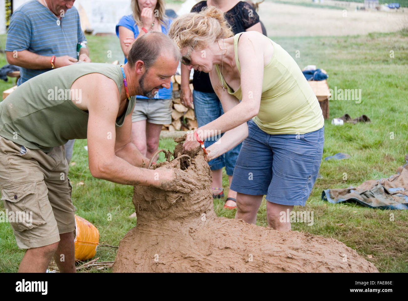 CHEPSTOW, WALES - July 2014: smoothing mud over a willow frame building ...