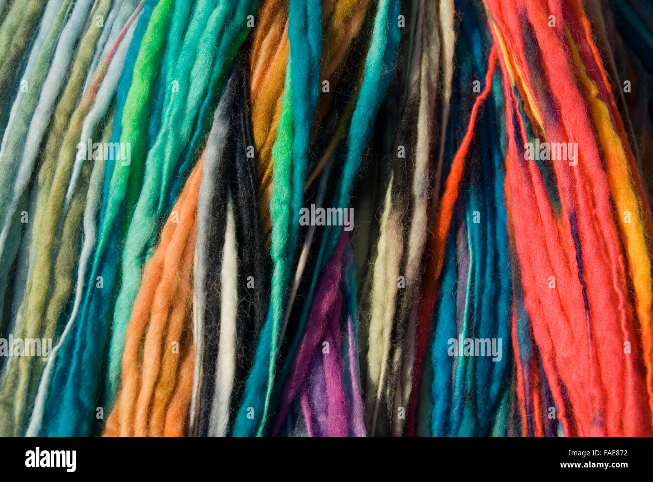 Close up on colourful handmade, spun, dyed wool strands hanging on a ...