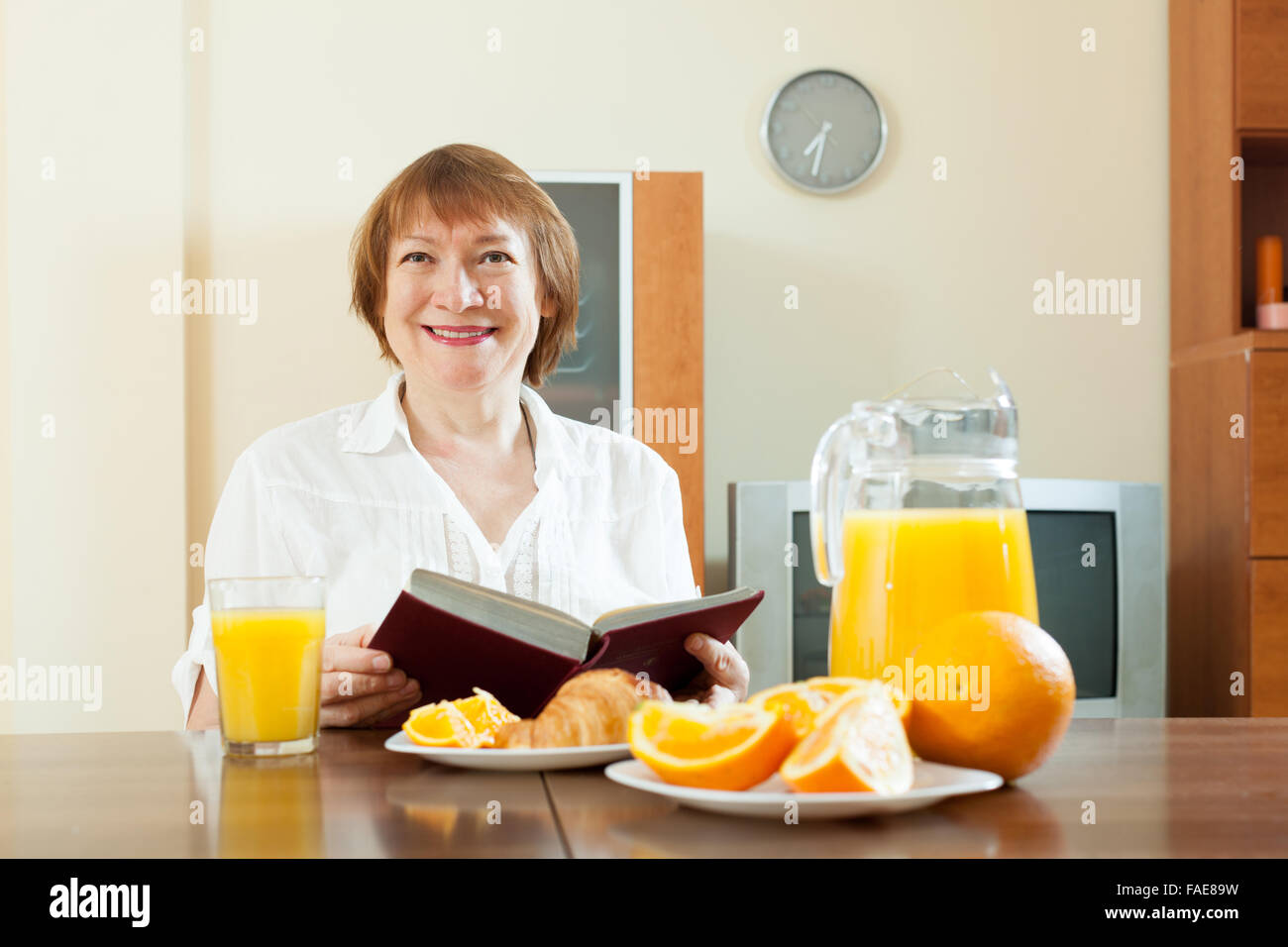 Woman reading book during breakfast hi-res stock photography and images ...