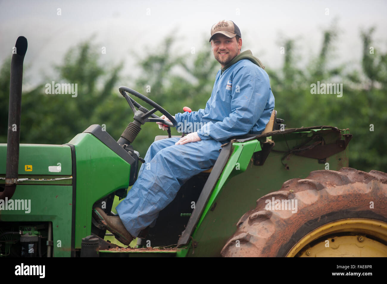 Farmer sitting on his tractor Stock Photo - Alamy
