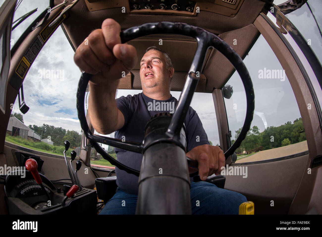 Farmer driving his tractor Stock Photo - Alamy