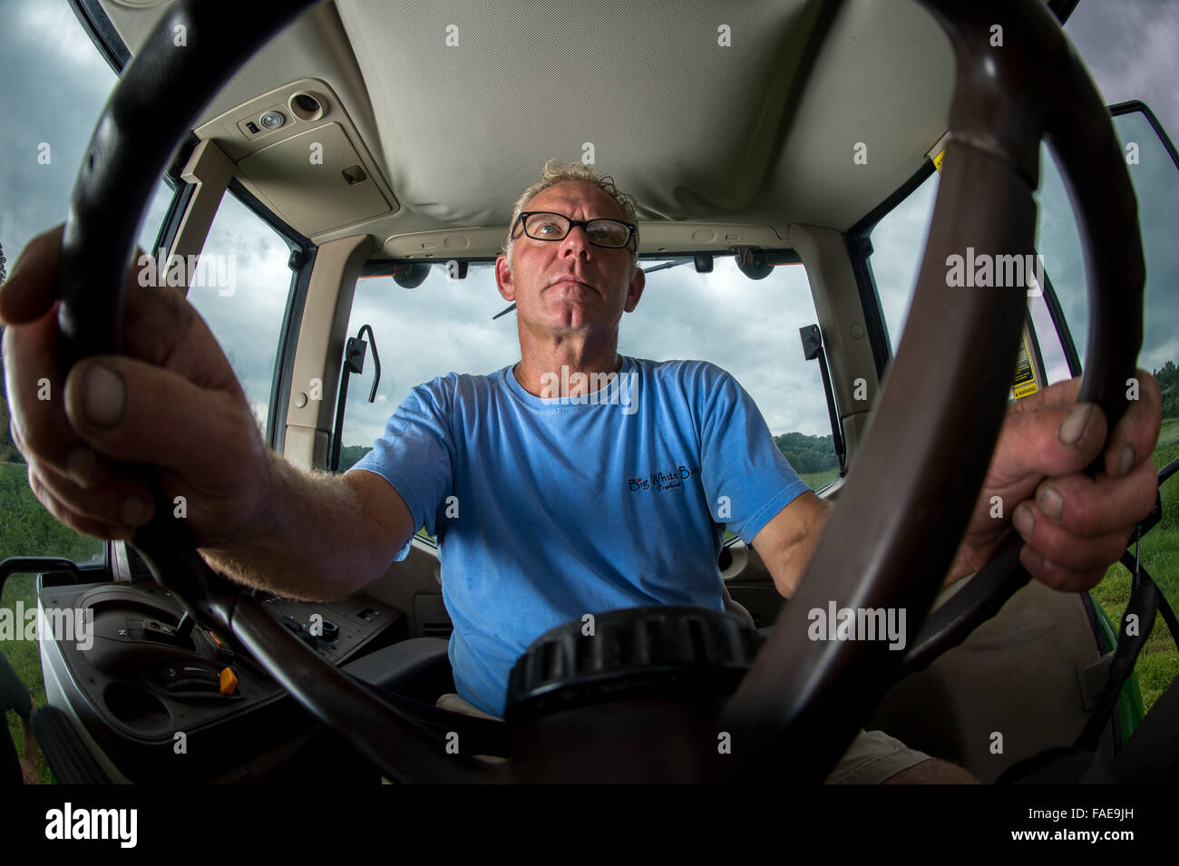Farmer driving his tractor Stock Photo - Alamy