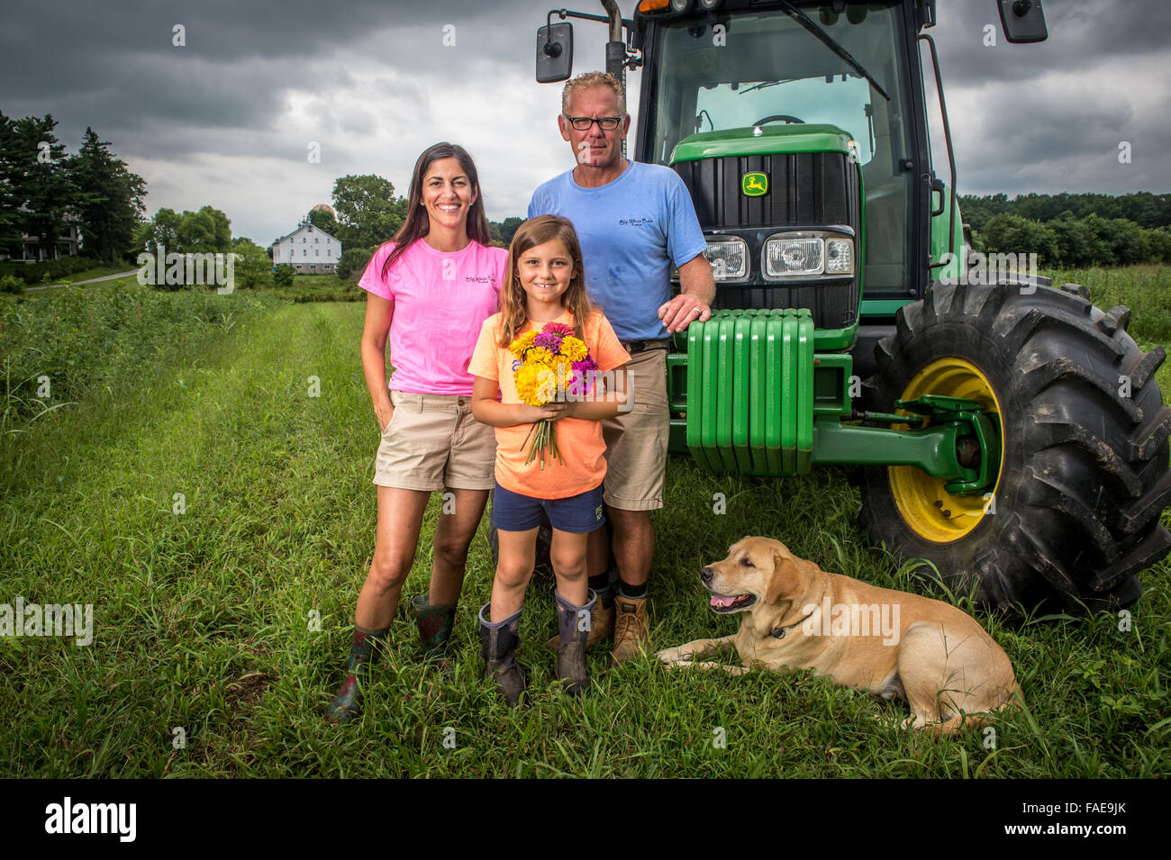 Farmer standing with his family in front of his tractor Stock Photo - Alamy