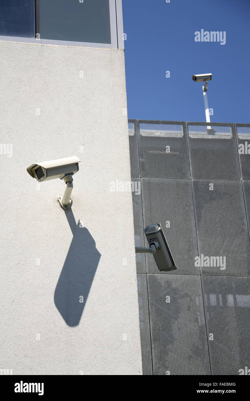 White security cameras mounted on white wall Stock Photo - Alamy