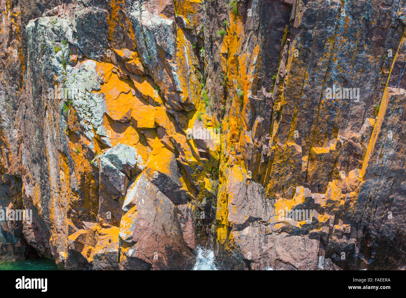 Closeup of yellow gold rock wall on cliff on the north shore of Lake ...
