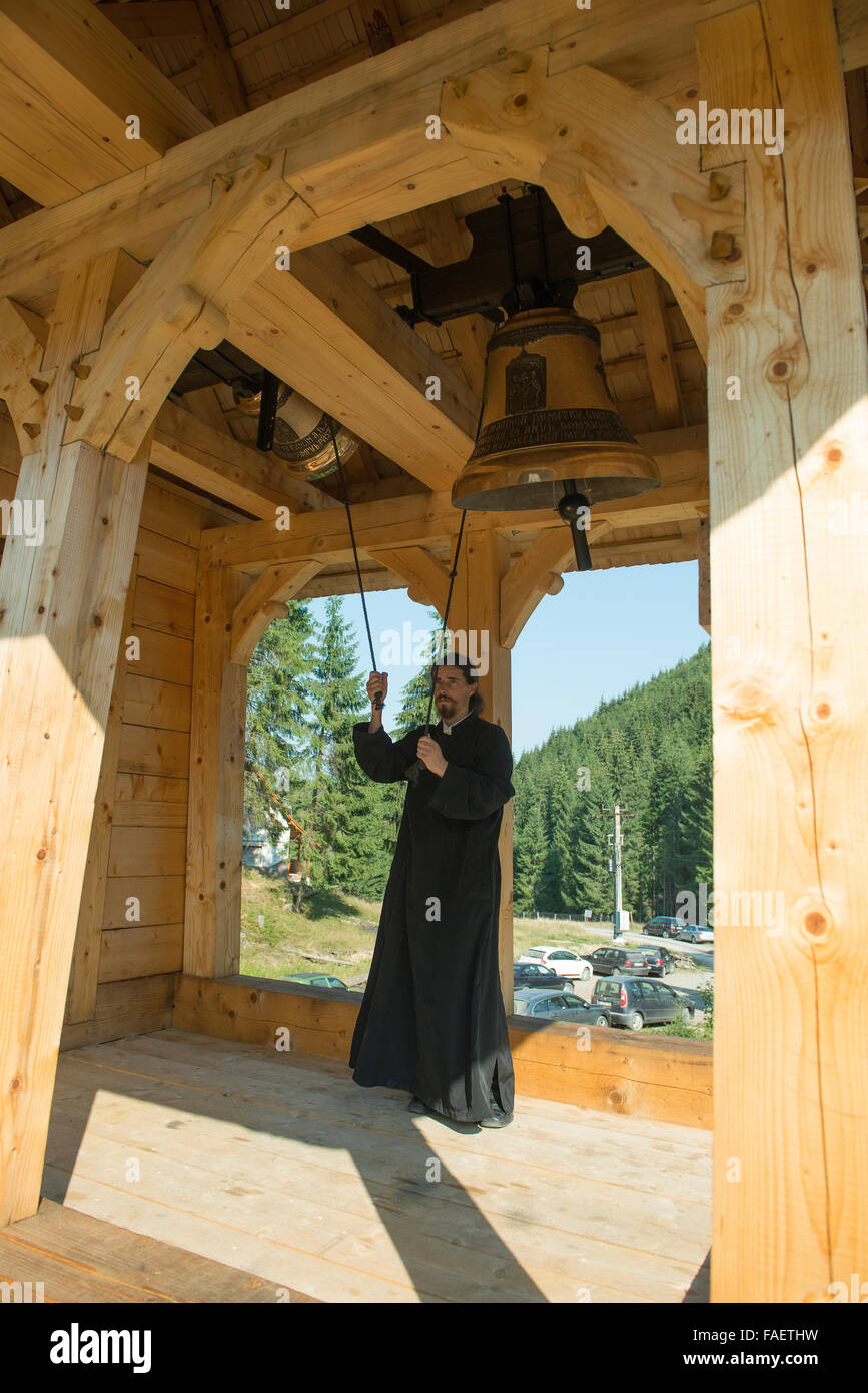 a young priest rings a bell Stock Photo - Alamy