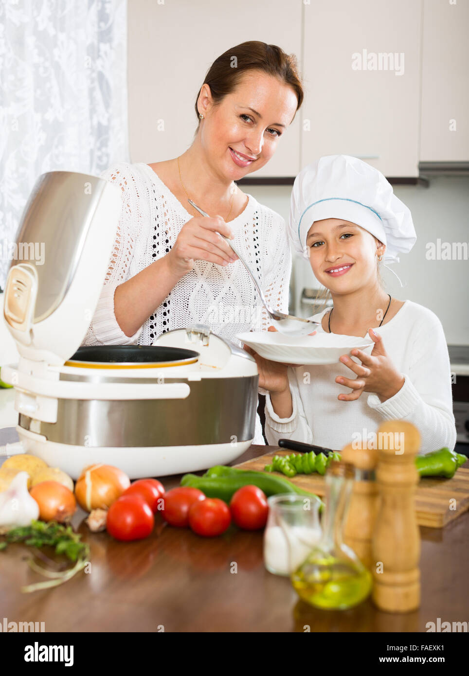 Slow cooker helping mother and girl to prepare dinner at home Stock ...