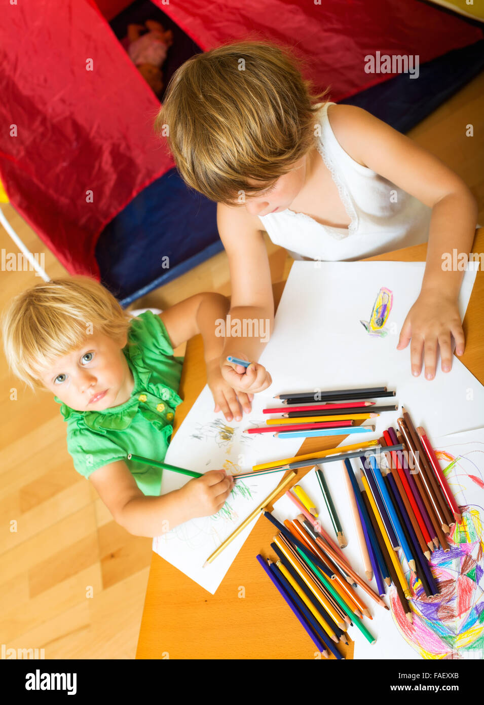 Two children together with pencils in home interior Stock Photo - Alamy