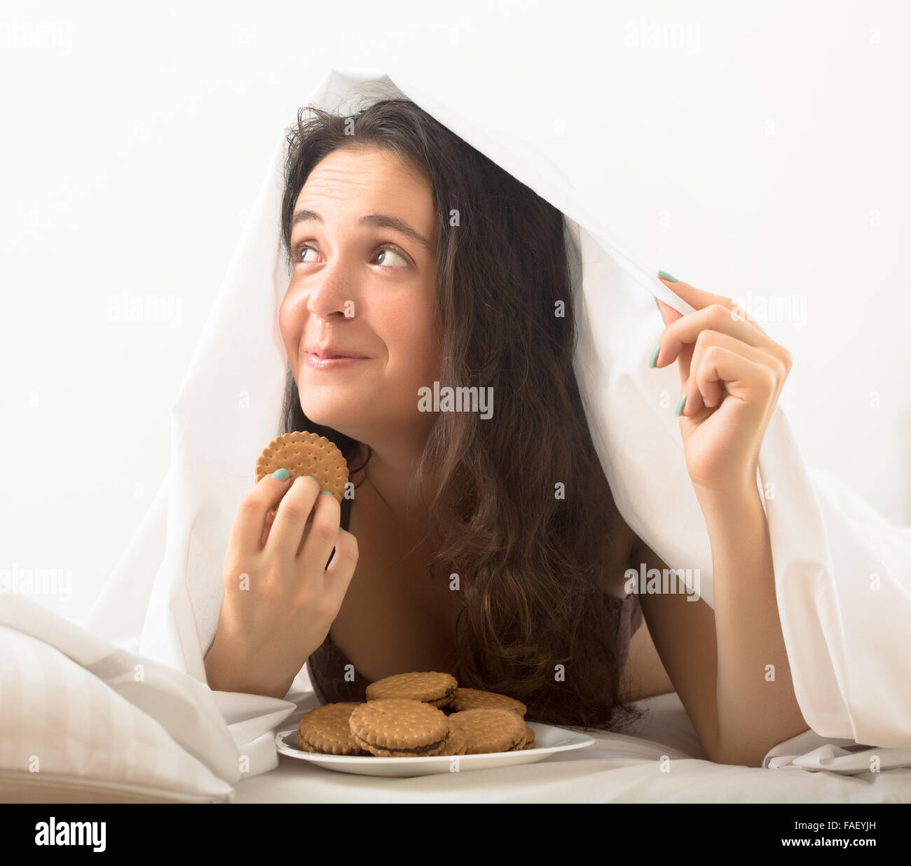 Girl eating sweet chocolate chip cookies in bed at home Stock Photo - Alamy