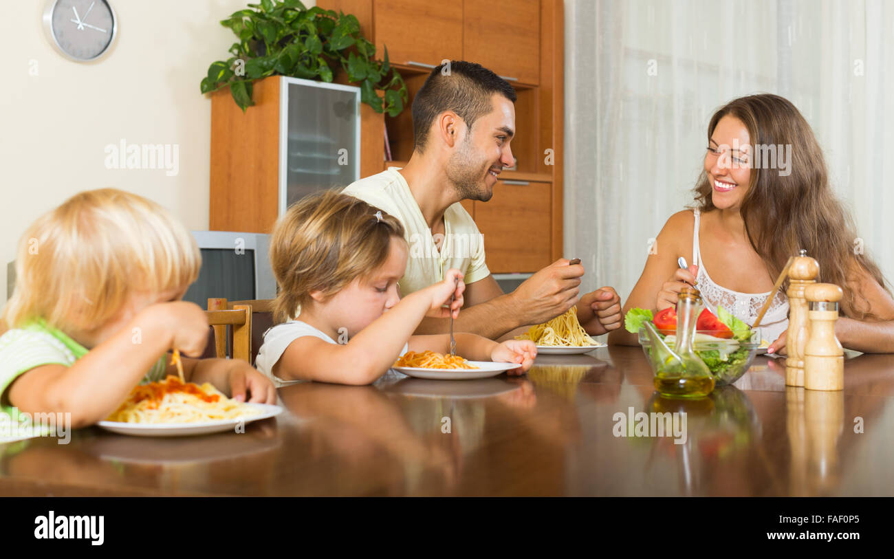 happy family of four eating pasta at home together Stock Photo - Alamy