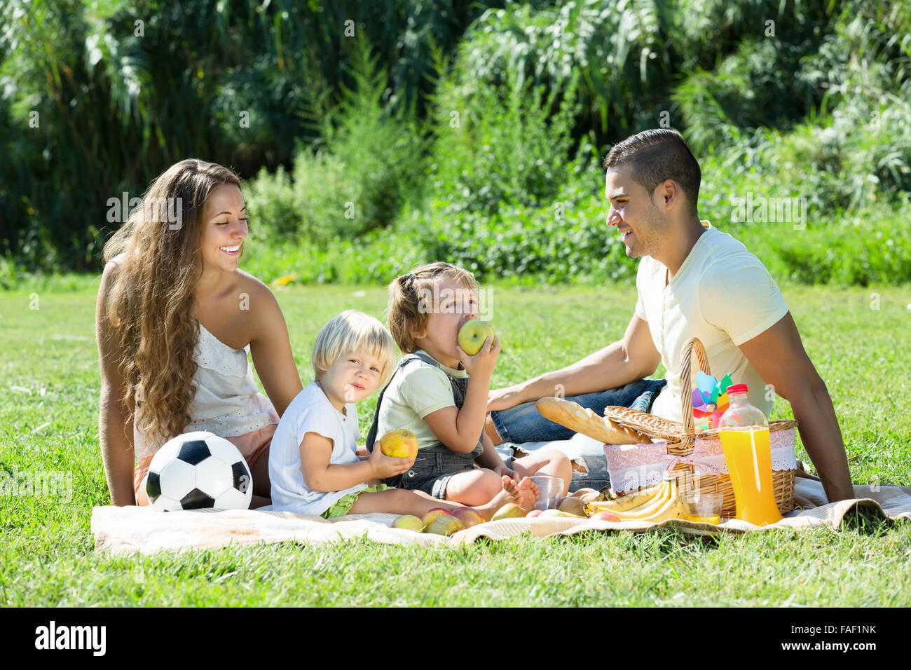 European family with little children having picnic in park Stock Photo ...