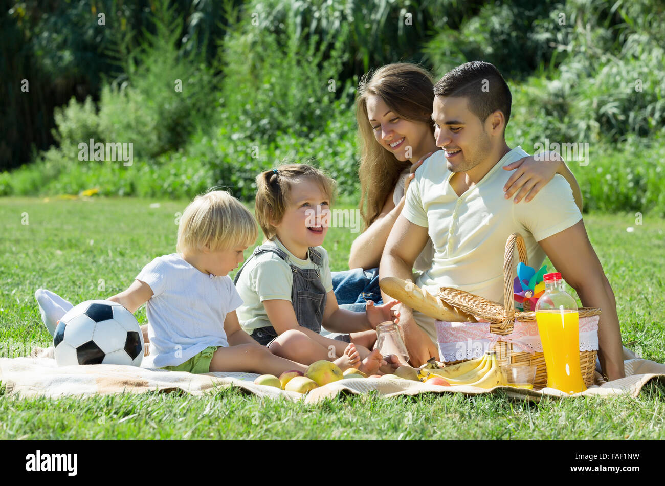 Young parents with little daughters having holiday with picnicin in ...