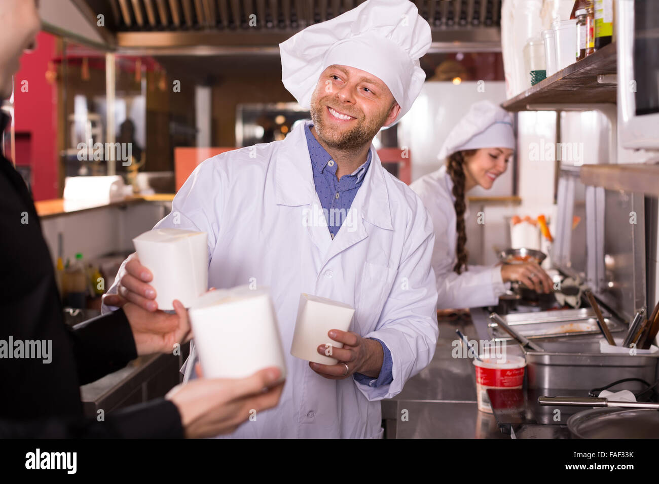 Cheerful man purchasing fast food in cardboard box at cafe Stock Photo ...