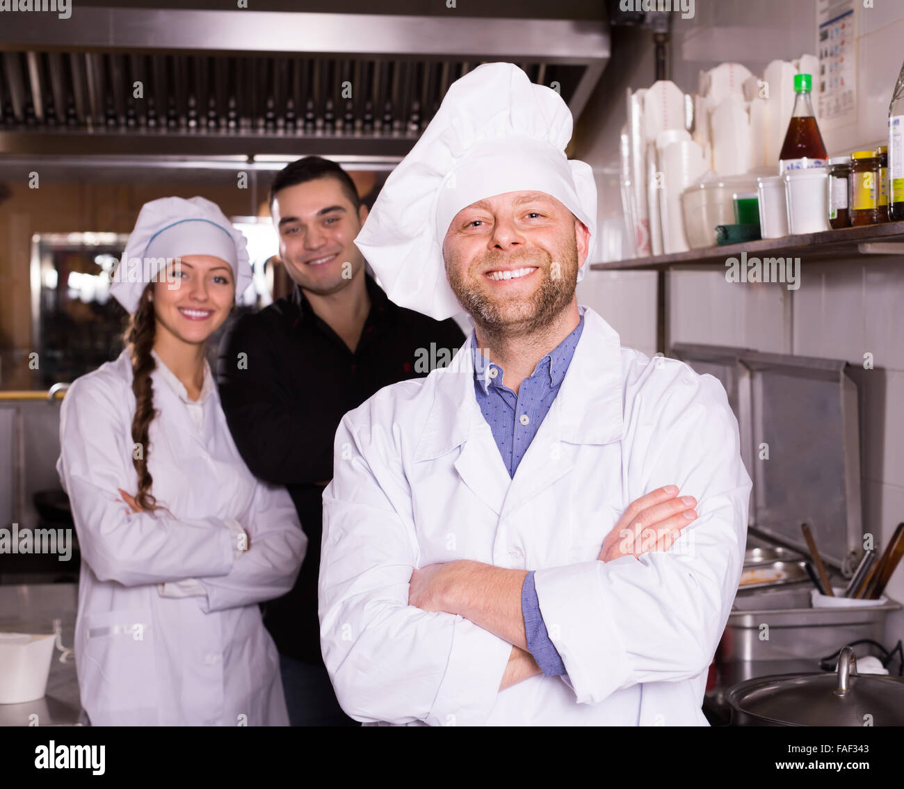 Portrait of hospitable chef and two helpers at fastfood place Stock ...