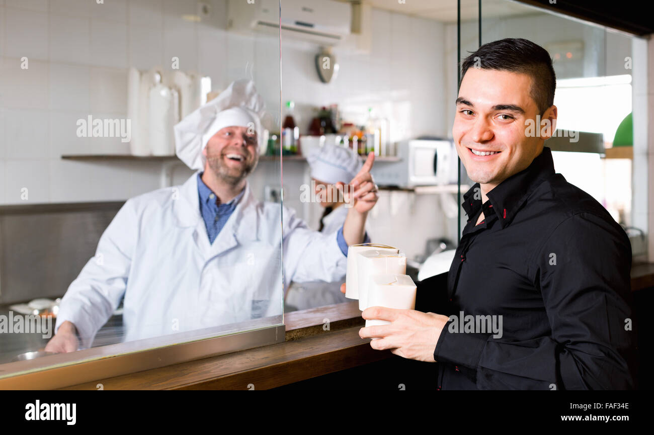Portrait of smiling customer, professional chefs at fastfood place ...