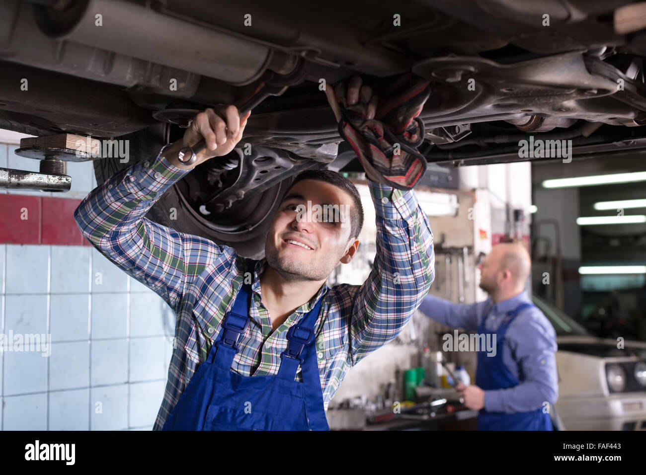 Positive mechanics fixing car Stock Photo - Alamy