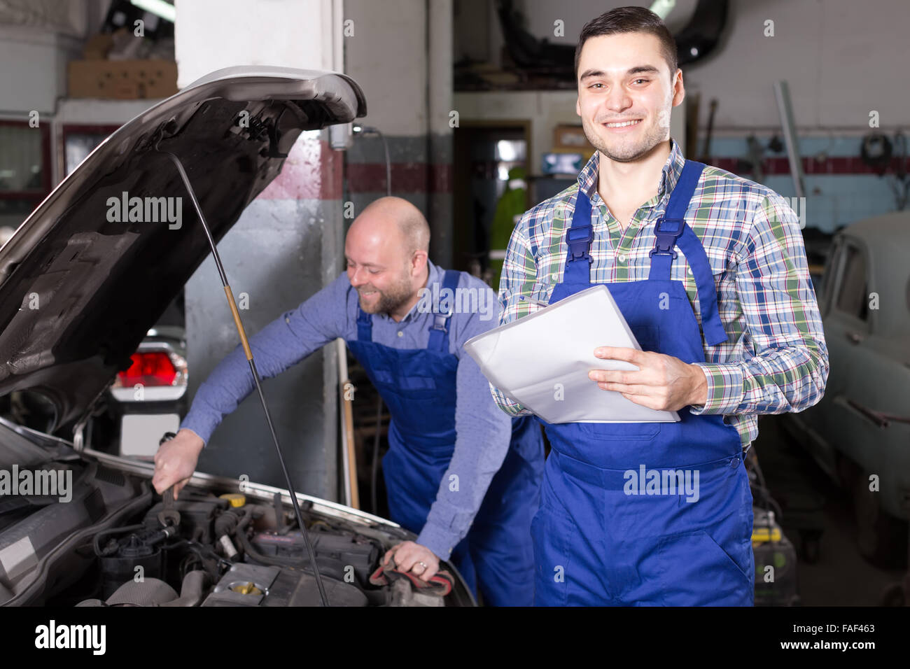 Happy smiling insurance agent calculating loss with the help of a ...