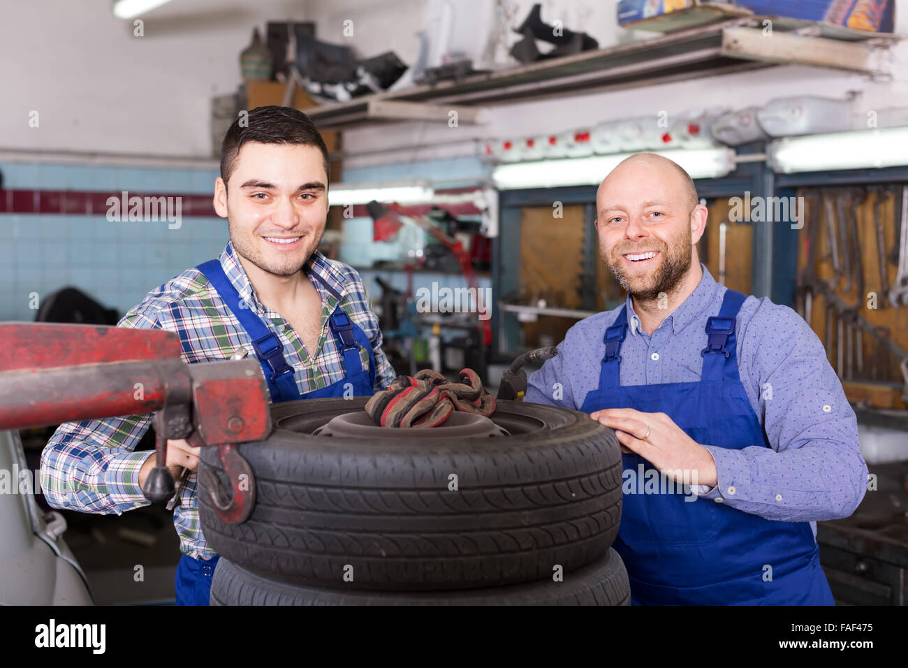 Portrait of two smiling successful car mechanics at workshop Stock ...
