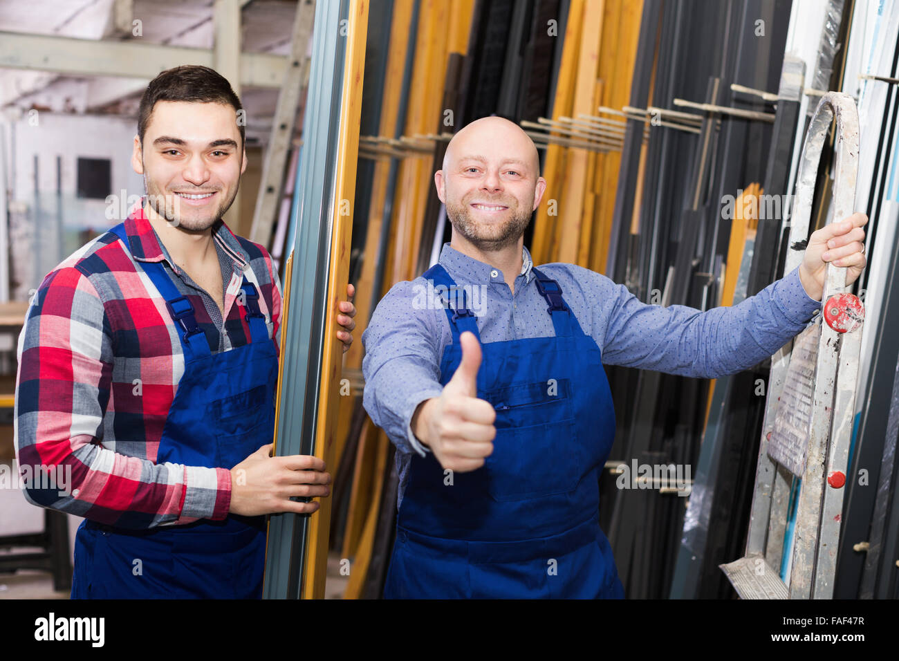 Two happy adult workers posing in PVC shop indoor Stock Photo - Alamy