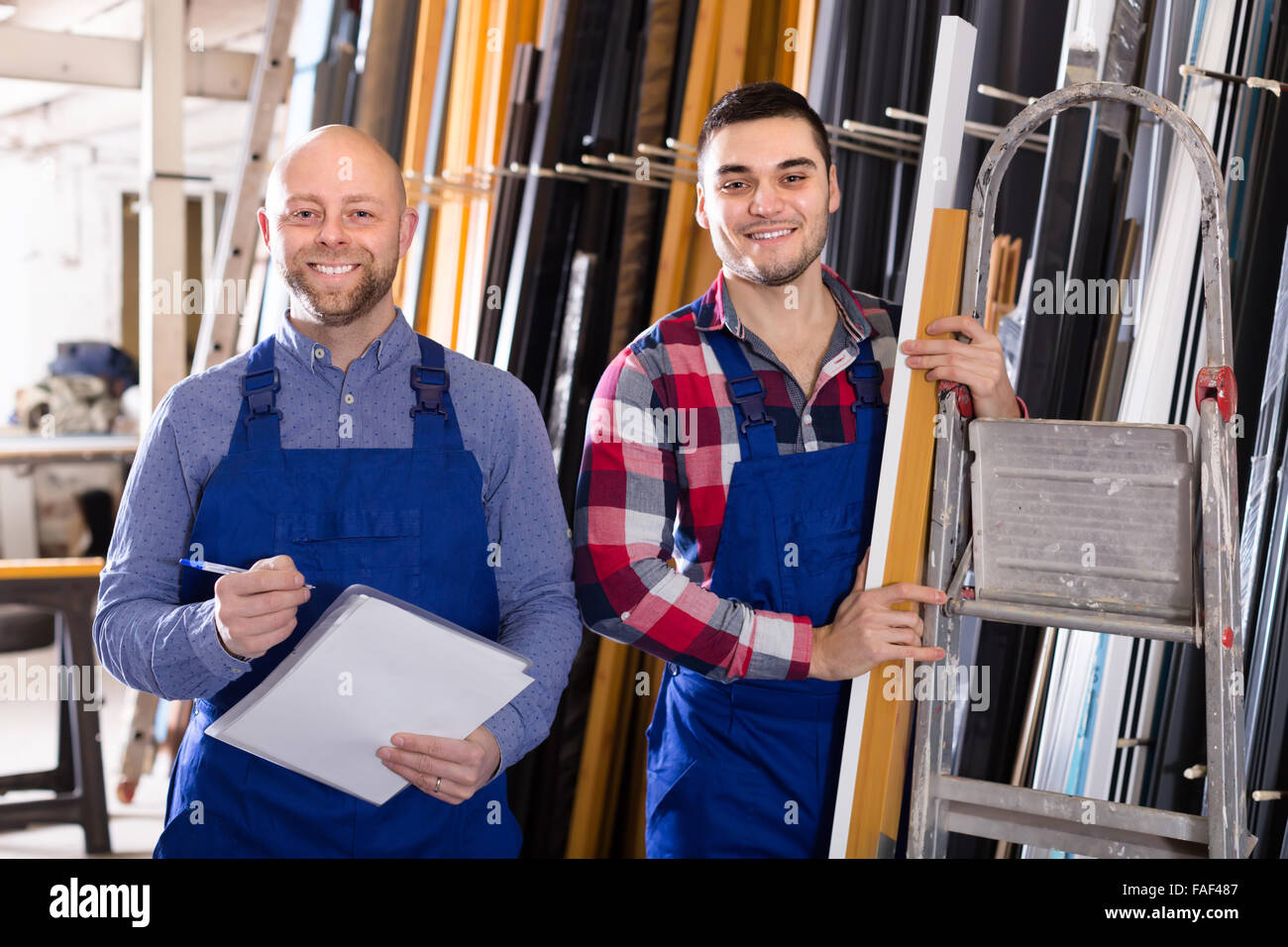 Two happy smiling workmen enjoying of production plan overfulfilment at ...