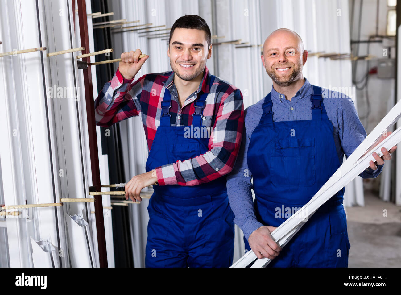 Production workers in coverall with different PVC window Stock Photo ...