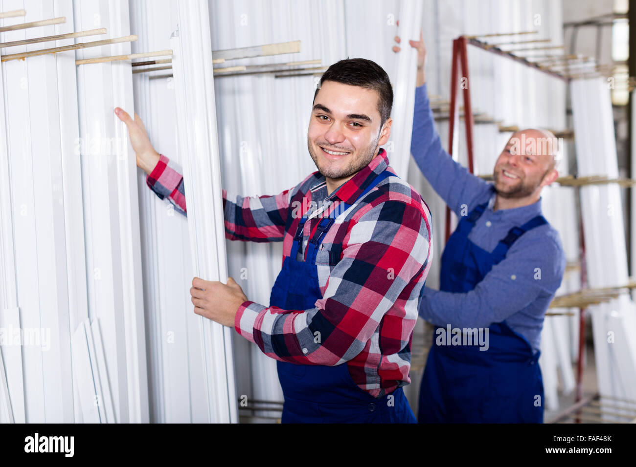 Couple of workers inspecting window frames at factory Stock Photo - Alamy
