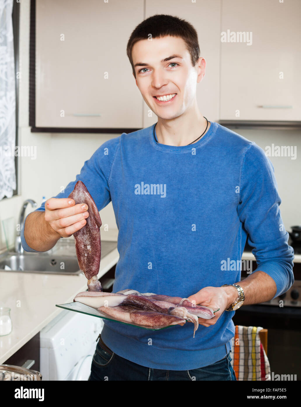 man holding raw calamari at home kitchen Stock Photo - Alamy