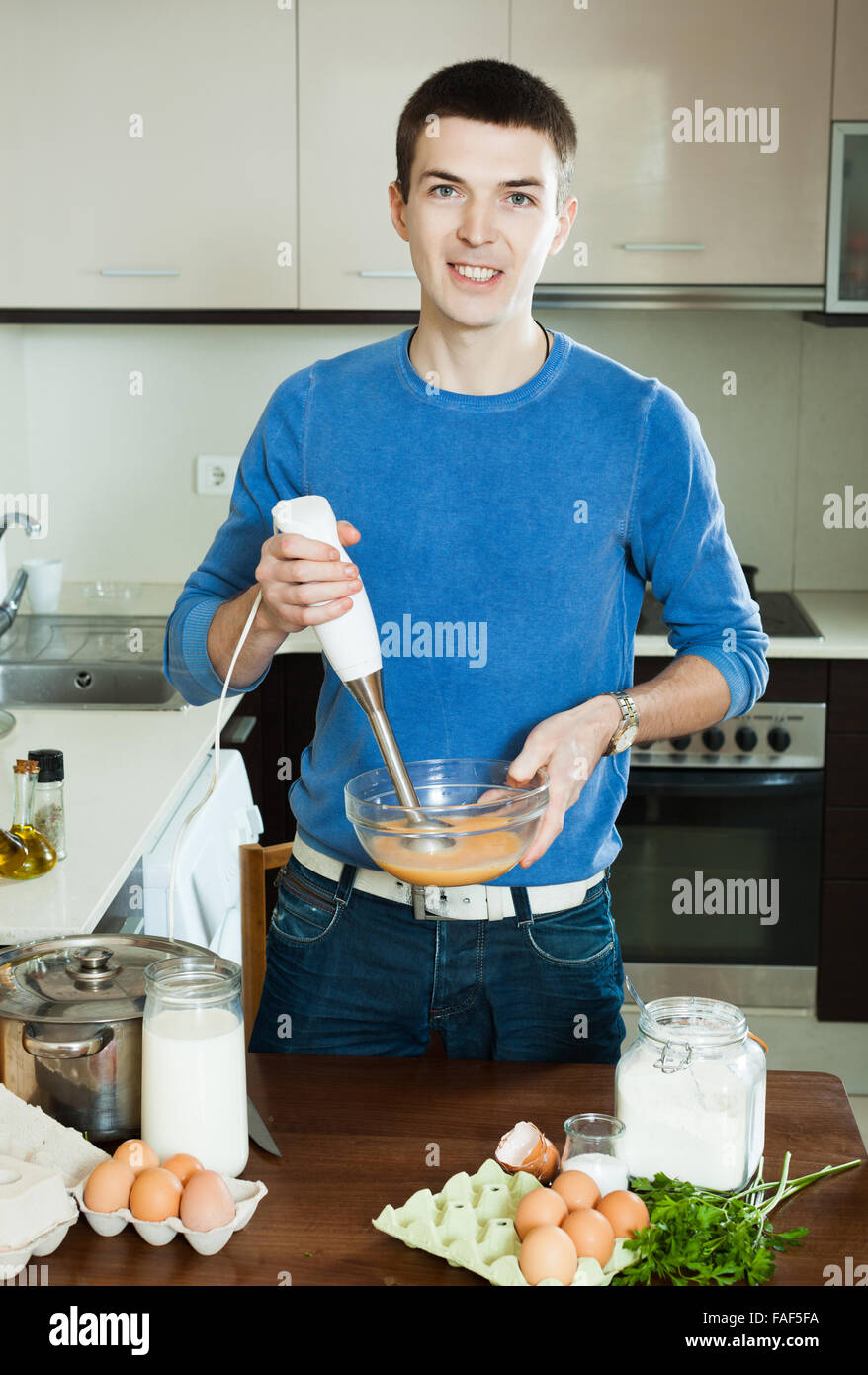 Guy cooking scrambled eggs for breakfast in home kitchen Stock Photo ...