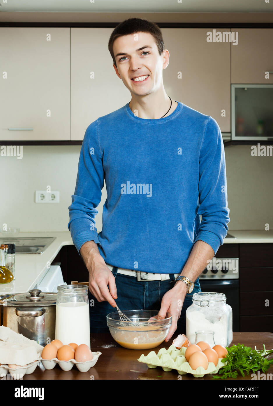 man cooking scrambled eggs for breakfast in home kitchen Stock Photo ...