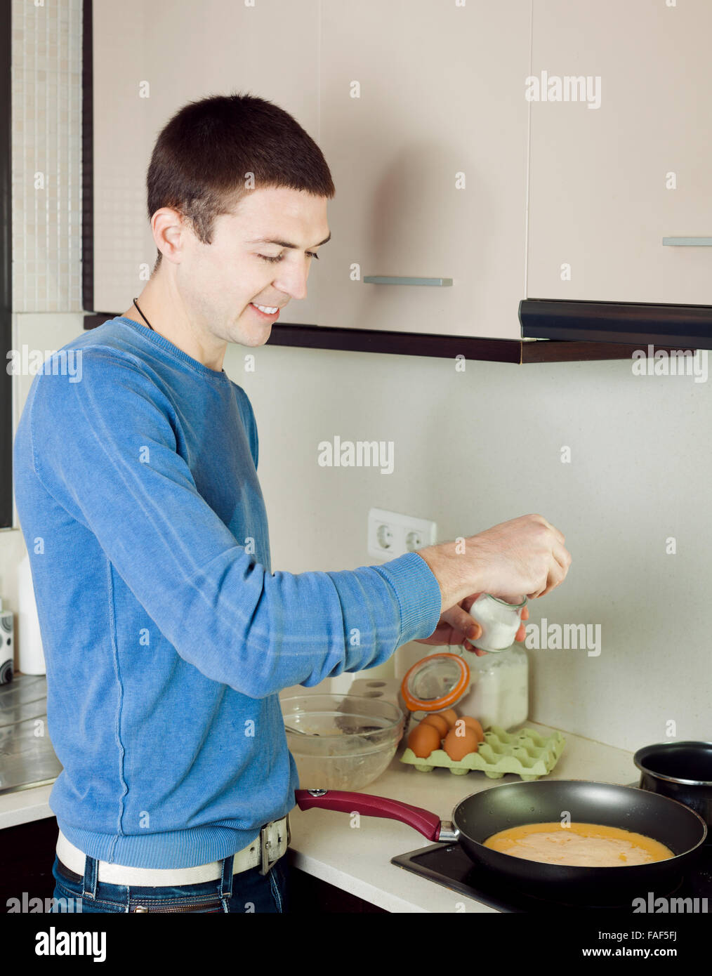 Man cooking scrambled eggs in pan in kitchen Stock Photo - Alamy