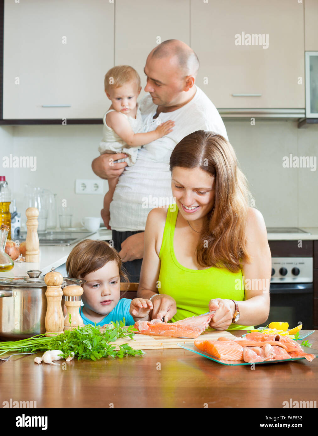Happy parents with children docile fish cooking in a home kitchen Stock ...