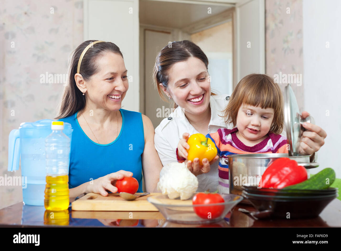 Happy family together cooking lunch with vegetables Stock Photo - Alamy