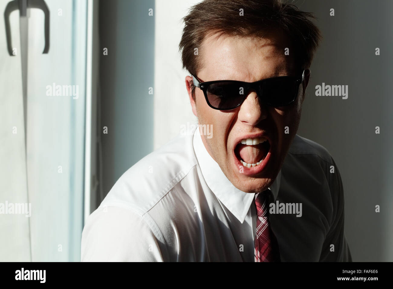 Angry businessman in sunglasses screaming Stock Photo - Alamy