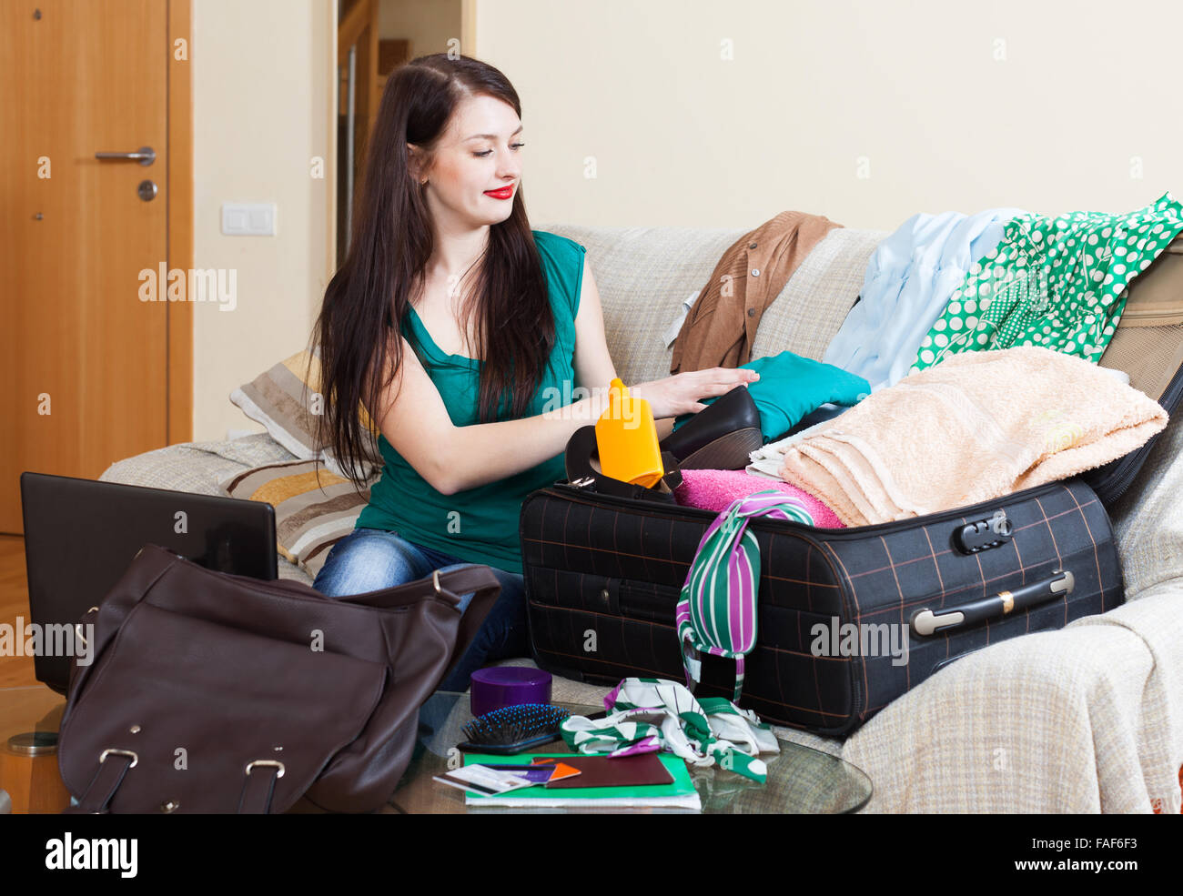 brunette woman packing suitcases at home Stock Photo - Alamy